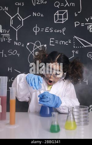 funny scientist girl with gloves and goggles in lab coat with chemical ...