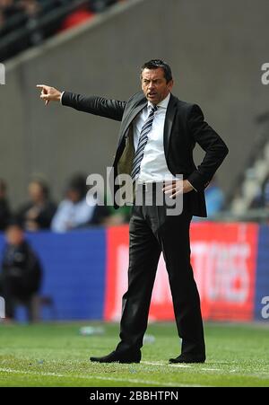 Southend United manager Phil Brown (left) looks on from the stands ...