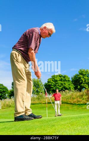 Active young man playing in the surf during a vibrant blood red sunset ...