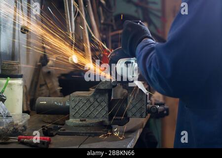 Photo of mechanic grinding metal plate in workshop Stock Photo - Alamy