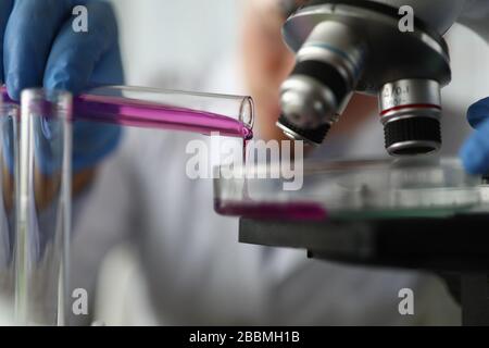 Assistant pouring liquid into flask Stock Photo - Alamy
