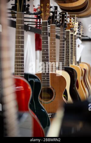 Close up of classic guitar drapped in a row in a huge musical shop ...