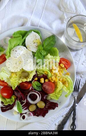 fresh green lettuce salad with mozzarella and herbs in a bowl, on a ...