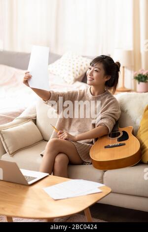 Young Chinese woman writing music at home Stock Photo - Alamy