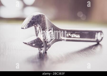 Wrench, French key, on blurred background Stock Photo - Alamy