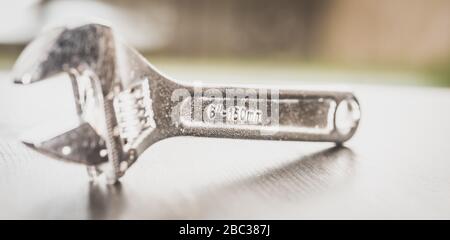 Wrench, French key, on blurred background Stock Photo - Alamy
