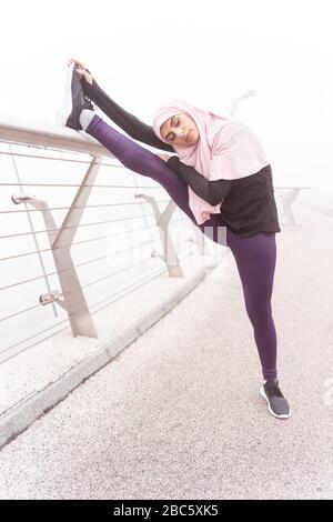 Muslim Woman Athlete Stretching on Running Track in Hijab at Outdoor ...