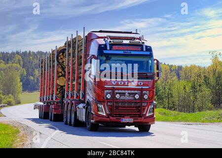 A blue modern timber truck transports round forest logs in the evening ...