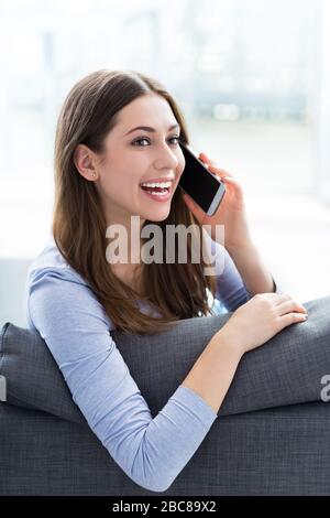 Young adult woman using smartphone and laptop for remote work outdoors ...