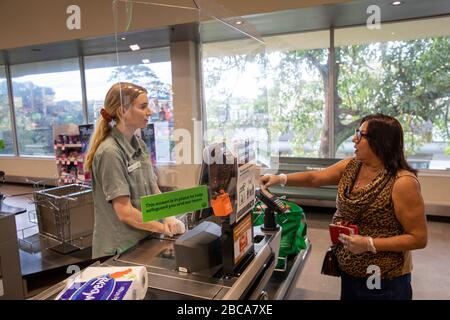 Girl checkout employee in Sydney woolworths supermarket stood behind ...