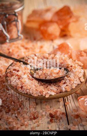 Crystals of pink Himalayan salt on brown wooden table. Studio Photo ...