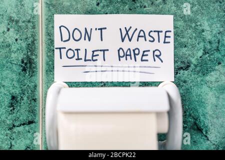 Don't waste the toilet paper. Message written on a paper with a ...