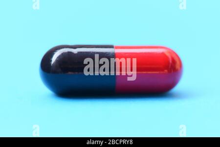 Selective focus of red and black capsule pills on stainless steel drug ...