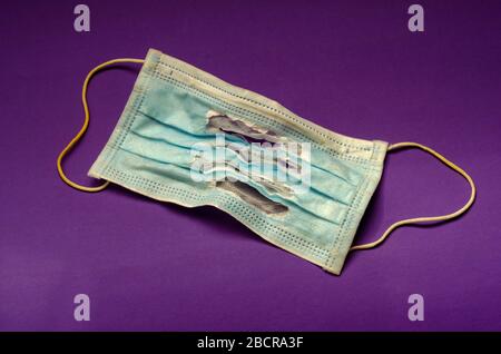 Used, broken, and torn medical face mask. Showing dangerous lack of ppe ...