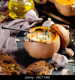 Pumpkin shell with homemade rustic pumpkin soup with seeds on metal ...