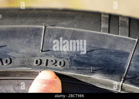 Side view of new tire with designation of week and year of tire ...
