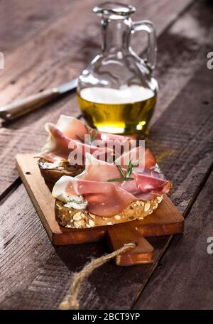 Delicious bruschettas with cream cheese, prosciutto, tomatoes and ...