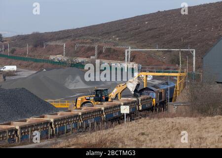 Cat loading shovel loading a freight train with railway ballast at ...