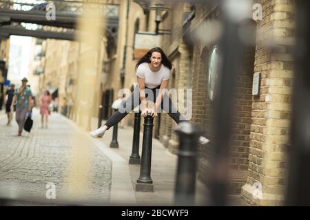 young woman jumping over a bollard in the street Stock Photo - Alamy