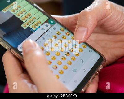 woman sends funny emoticons on an instant messaging application Stock ...