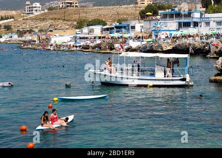 Chekka, Lebanon - June 4, 2017: Several tourists relaxing at the beach ...