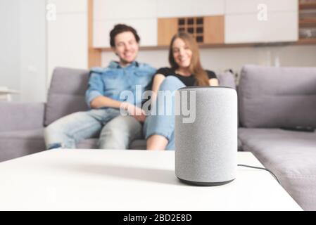 Couple talking command to smart speaker. Intelligent assistant in smart ...