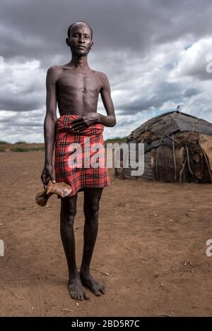A male member of the Dassanetch ethnic group or tribe poses holding his ...