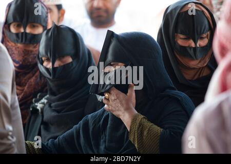 Omani women wearing a Batoola haggle for livestock at the friday market ...