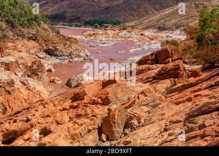 Rocky river bed Betsiboka river after heavy rain, red yellow water ...