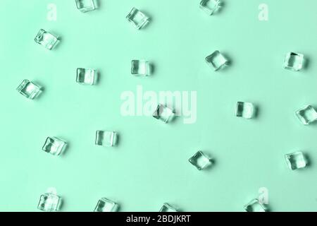 Flat lay pieces of ice toned in neo mint color on neo mint background ...