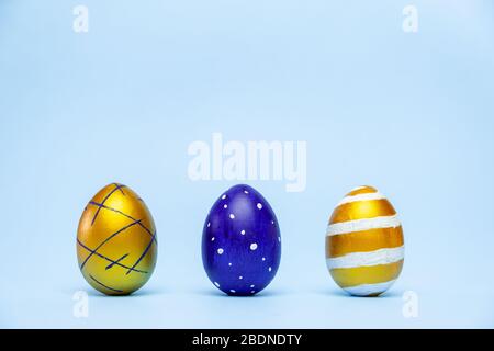 Three easter trendy colored classic blue and golden decorated eggs ...