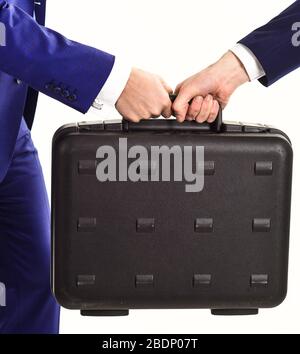 Business transfer deal. Handover of black suitcase in hands of partners ...
