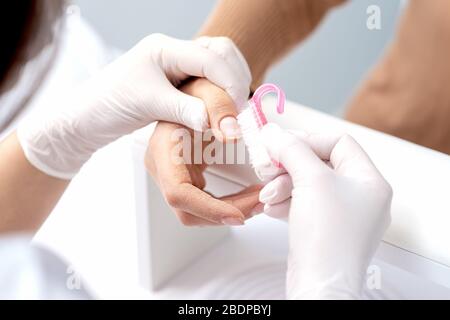 Manicure master removes dust from nails with a brush to cleaning nails ...