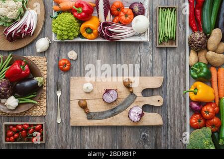 Freshly harvested vegetables, cooking utensils and chopping boards on a ...