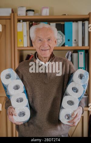 Old man holding two packs of toilet paper Stock Photo - Alamy