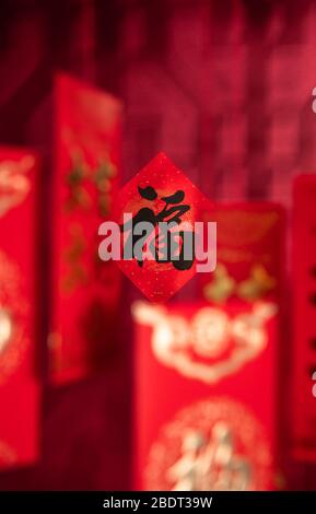 A vertical selective focus shot of red autumn leaves on a blurred ...