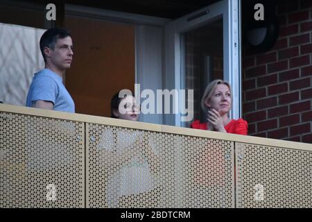 Erith, Kent, UK. 9th Apr, 2020. People in open windows and on balconies ...