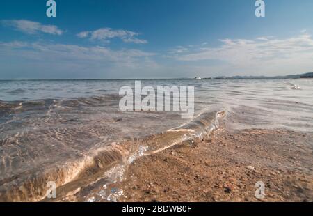 Close-up of small waves crashing on rocks. Creative. Stone beach with ...