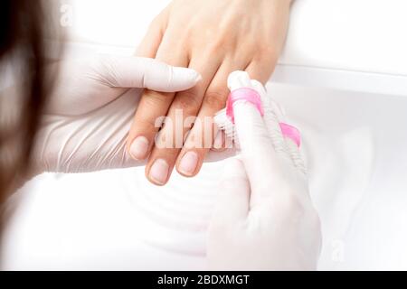 Manicure master removes dust from nails with a brush to cleaning nails ...