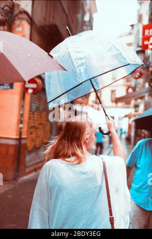 People walk under the rain in front of the Duomo gothic cathedral, in ...