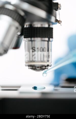 Microscope with drop of urine on glass slide in laboratory, closeup ...
