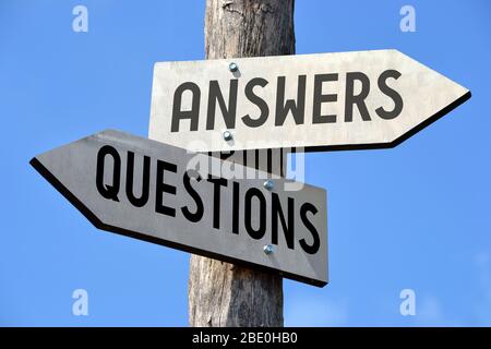 Questions and answers - wooden signpost with two arrows Stock Photo - Alamy