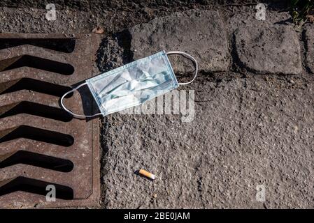 Discarded face mask lies on the branches of bushes. On Wednesday, March ...
