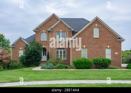 Traditional brick two story house with black shutters Stock Photo - Alamy