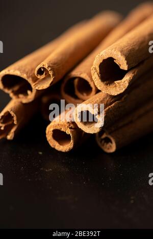 Natural Cinnamon sticks and cinnamon powder on dark concrete background ...