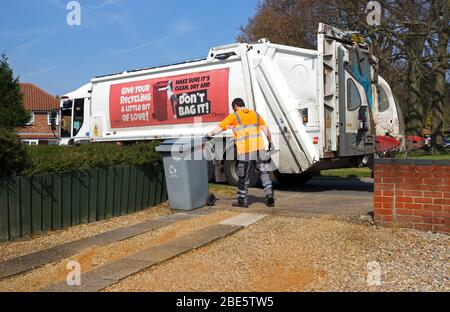 Binmen at work collecting and emptying recycling bins in a residential ...