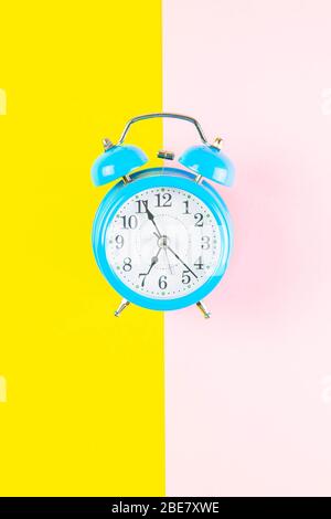 Ringing twin bell vintage classic alarm clock Isolated on blue pastel ...