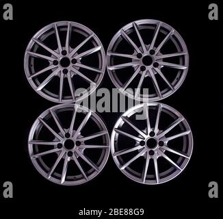 Designer alloy aluminium car wheels stacked on a metal rack in a shop ...