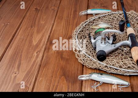 Fishing tackle - fishing spinning, hooks and lures on wooden background ...