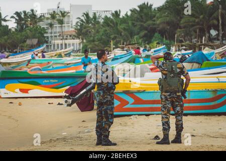 A Sri Lanka military police officer walks past the destroyed car of Maj ...